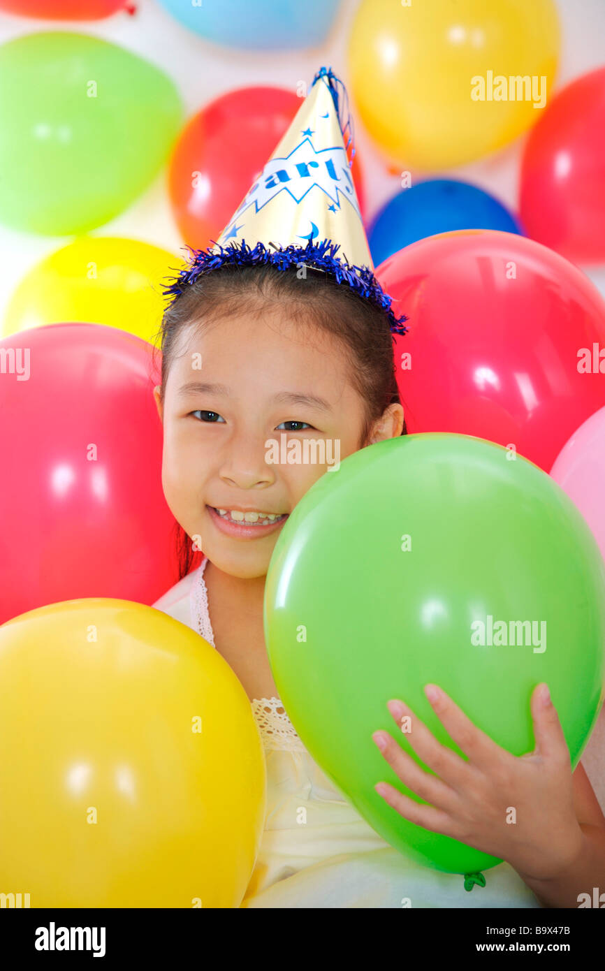 Girl wearing party hat surrounding with balloons Stock Photo - Alamy