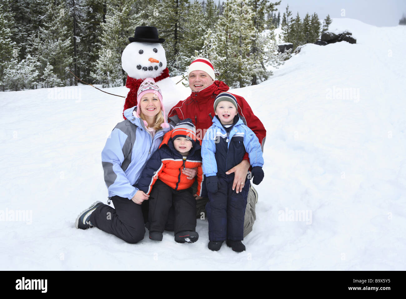 Family portrait by snowman Stock Photo - Alamy