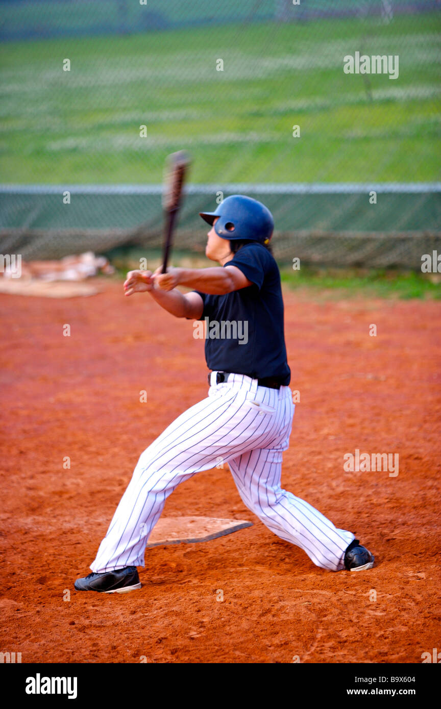 Baseball player holding baseball bat Stock Photo - Alamy