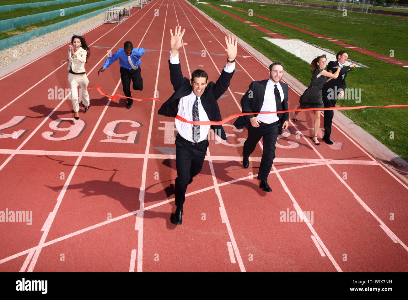 Businesspeople crossing finish line on track Stock Photo - Alamy