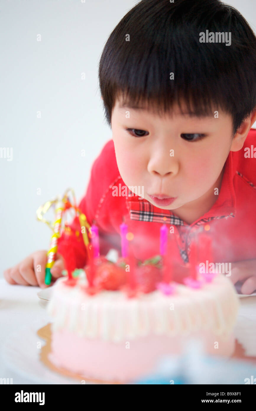 Boy browing candles at birthday party Stock Photo - Alamy