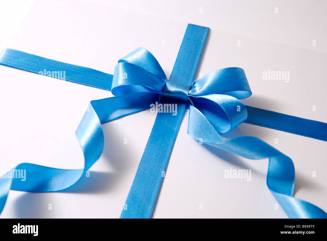 Wrapped gift with blue ribbon Stock Photo - Alamy
