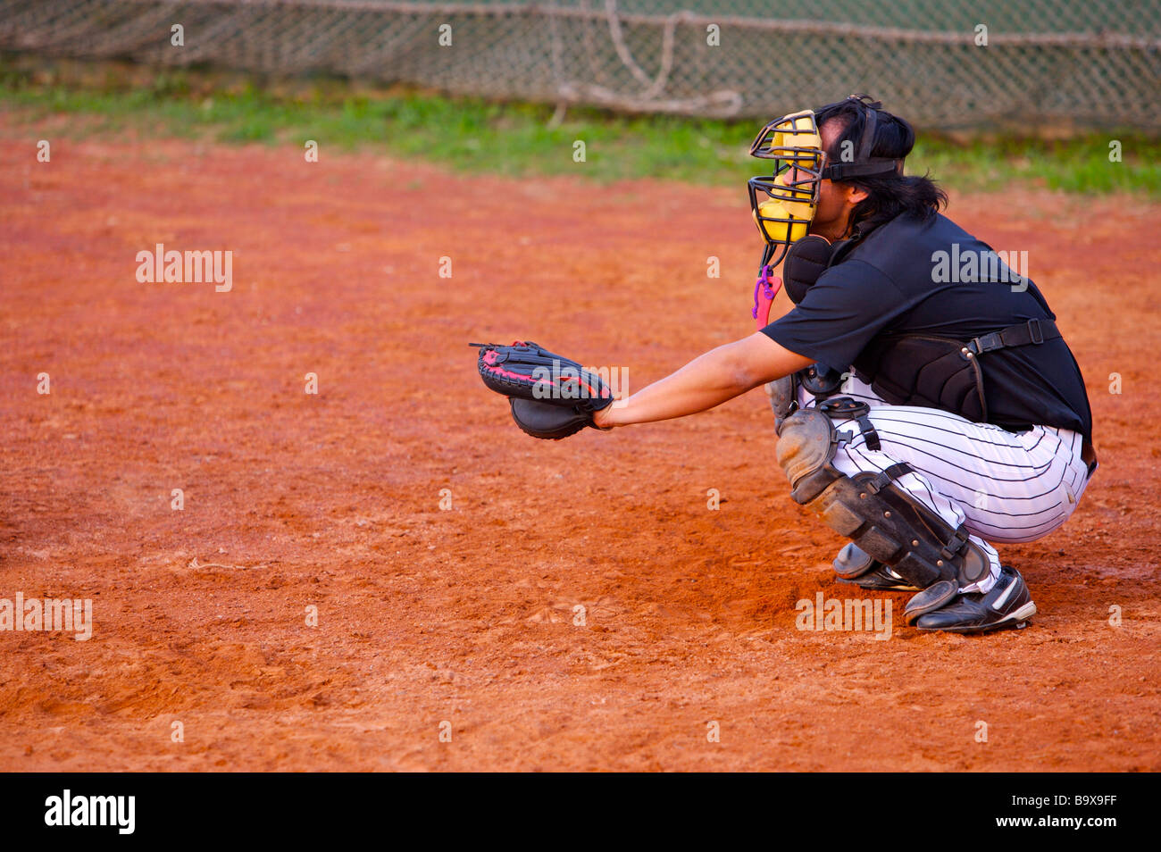 Baseball player crouching on playing field Stock Photo - Alamy