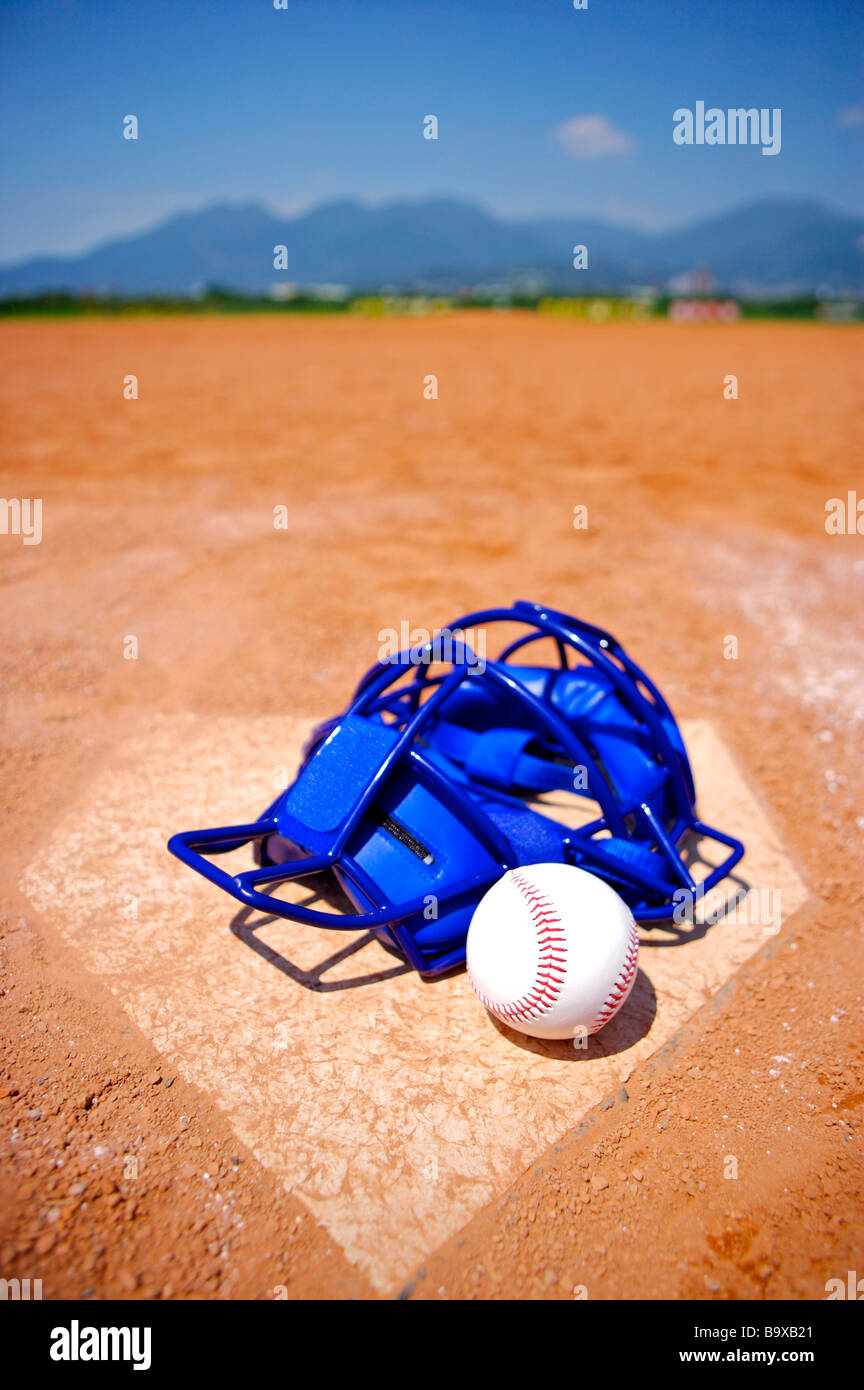 Baseball helmet and ball on home base Stock Photo - Alamy