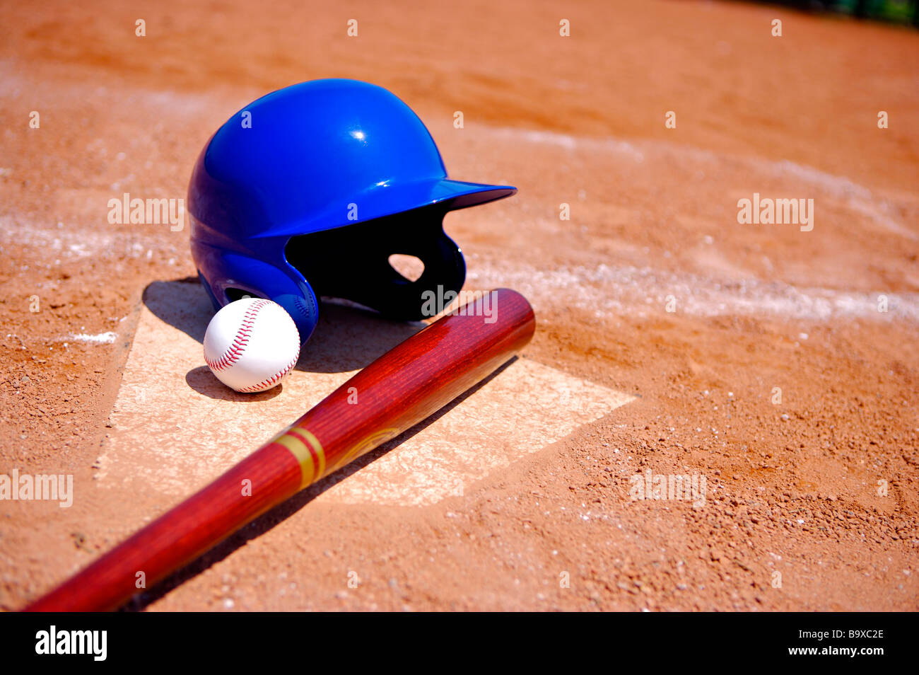 Baseball helmet ball and bat on home plate Stock Photo - Alamy