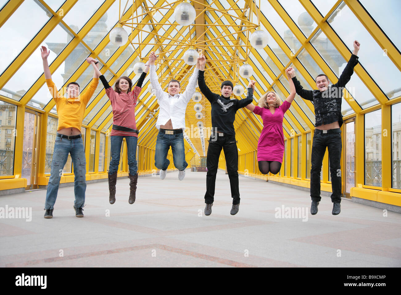 group of friends jump on footbridge taking as hands Stock Photo - Alamy