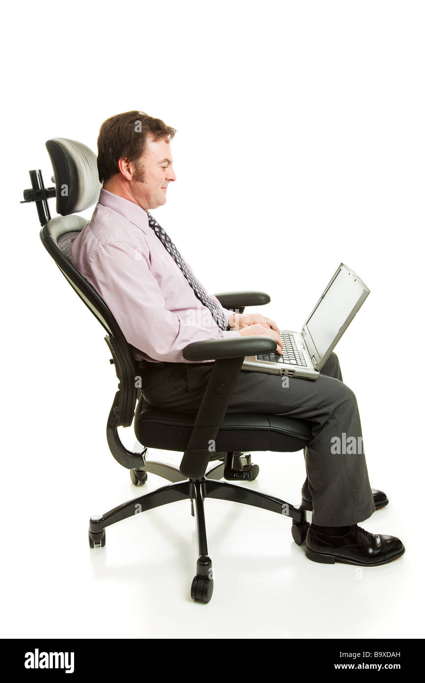 Business man working on his computer in an ergonomic office chair Full ...