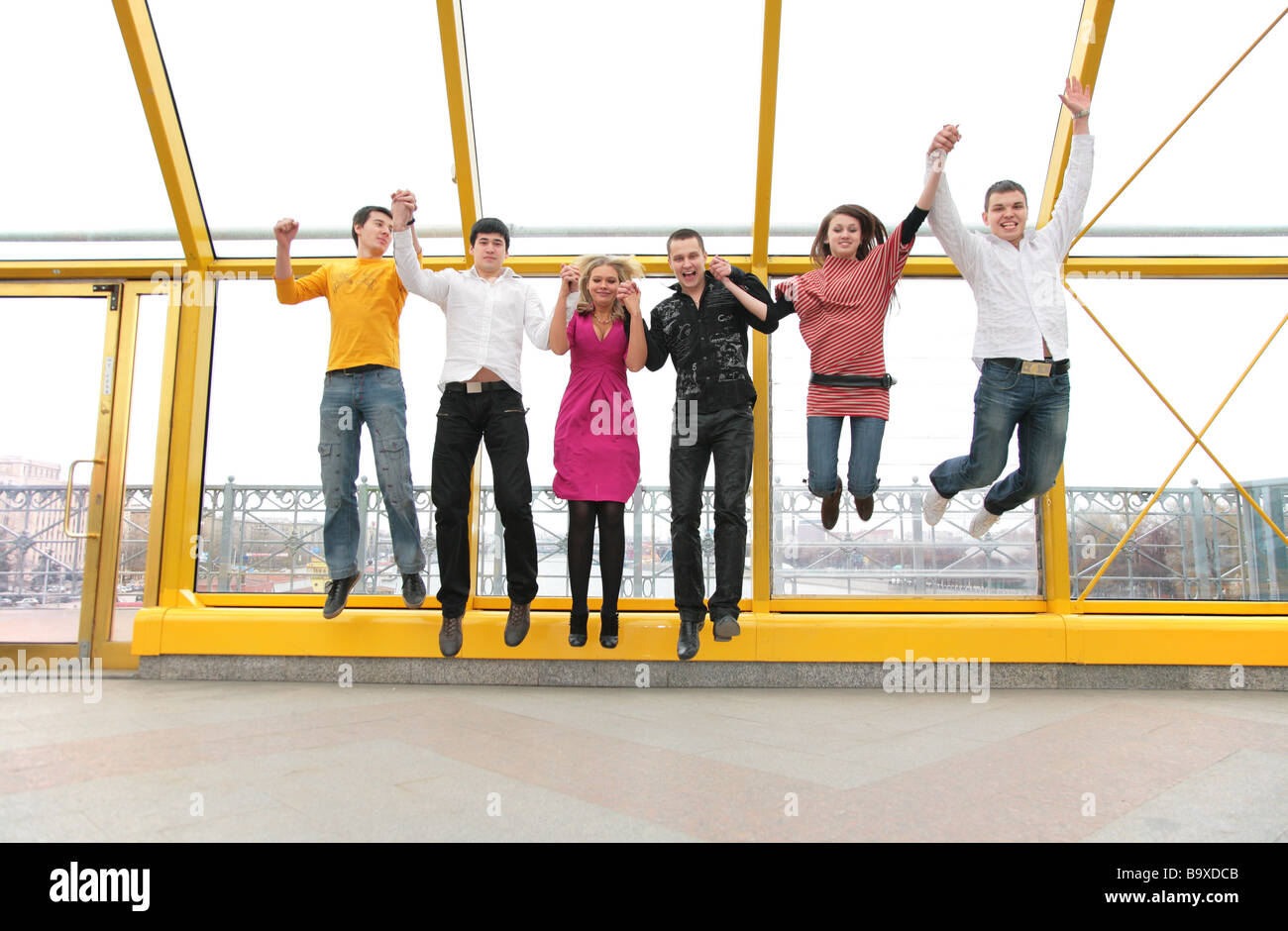 group of young people jump on footbridge Stock Photo - Alamy