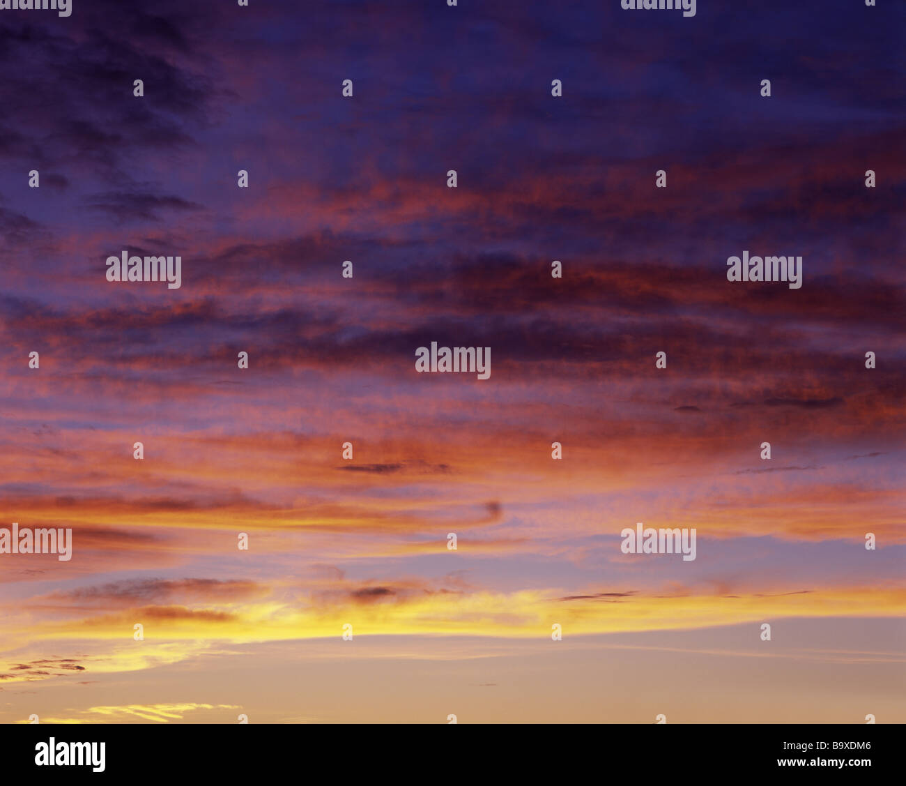 CLOUDSCAPE OF HORIZONTAL BANDS OF RED YELLOW CLOUDS ON PINK GLOW SKY ...