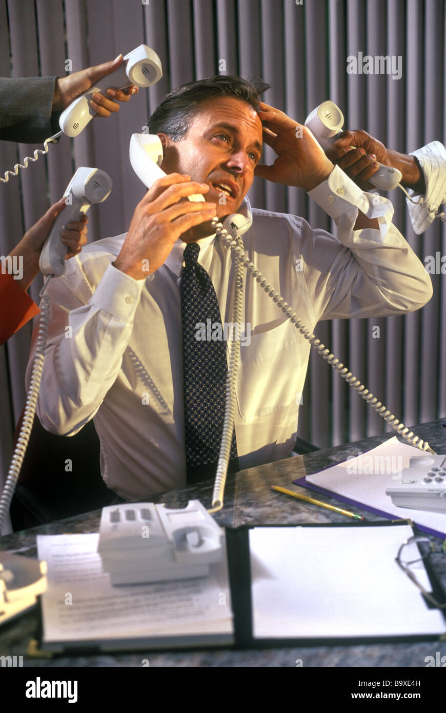 AMERICAN MALE OFFICE WORKER ANSWERING MANY TELEPHONES AT ONCE Stock ...