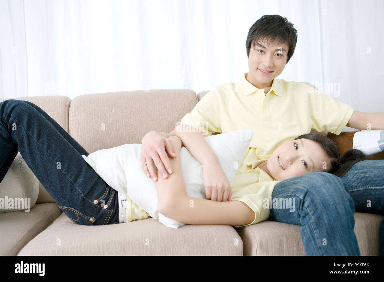 Young woman lying on man s lap on sofa smiling Stock Photo - Alamy