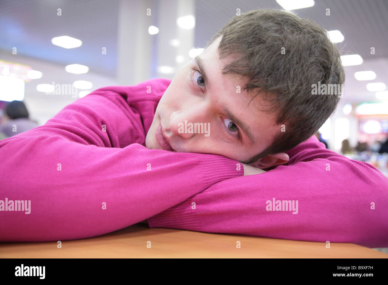 sad young man at table Stock Photo - Alamy