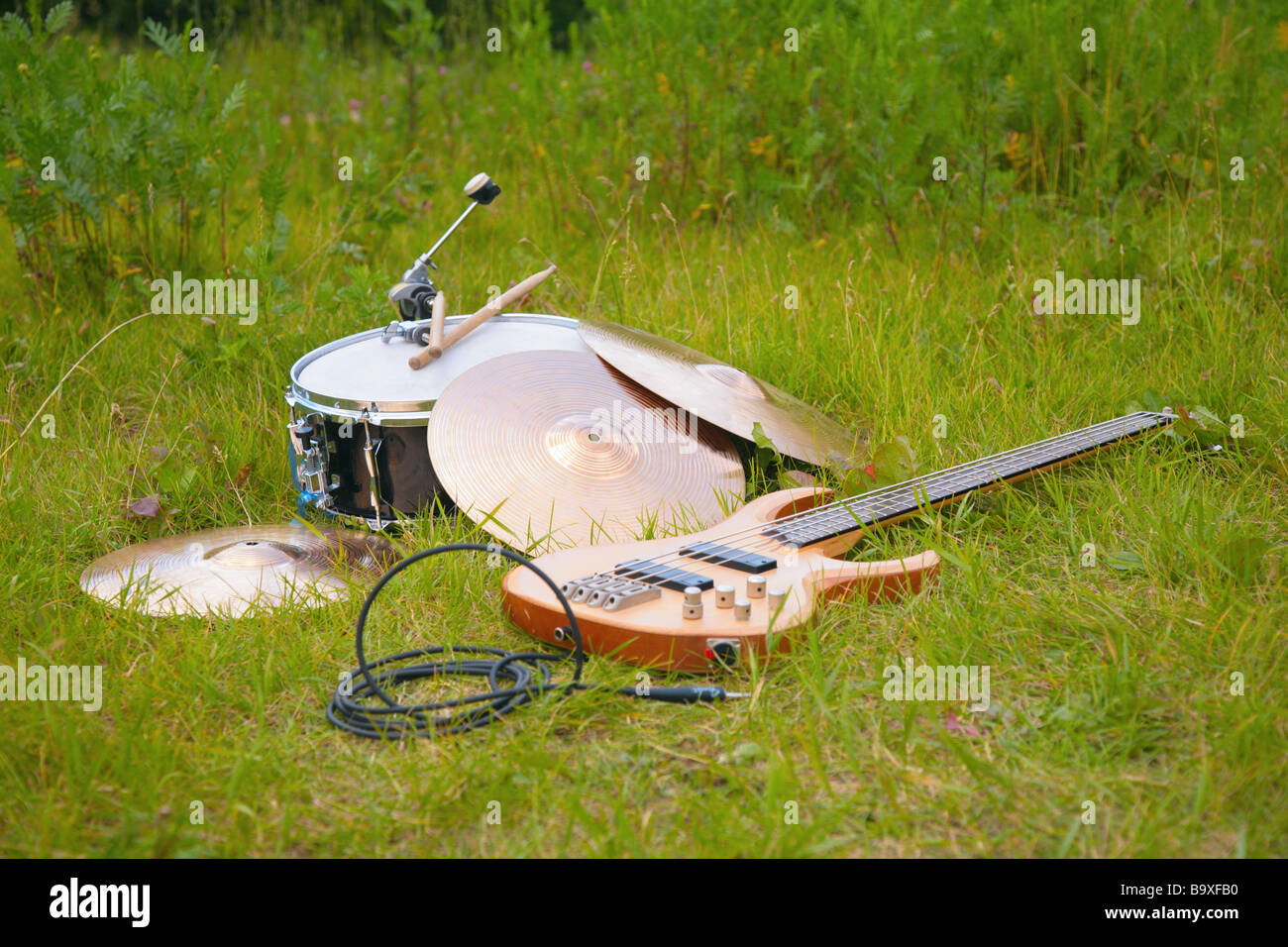 musical instruments, guitar, drum, plates on grass Stock Photo - Alamy