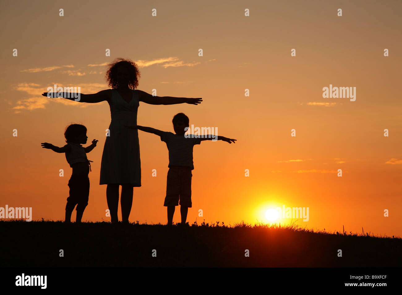 Mother and children on sunset sport training Stock Photo - Alamy
