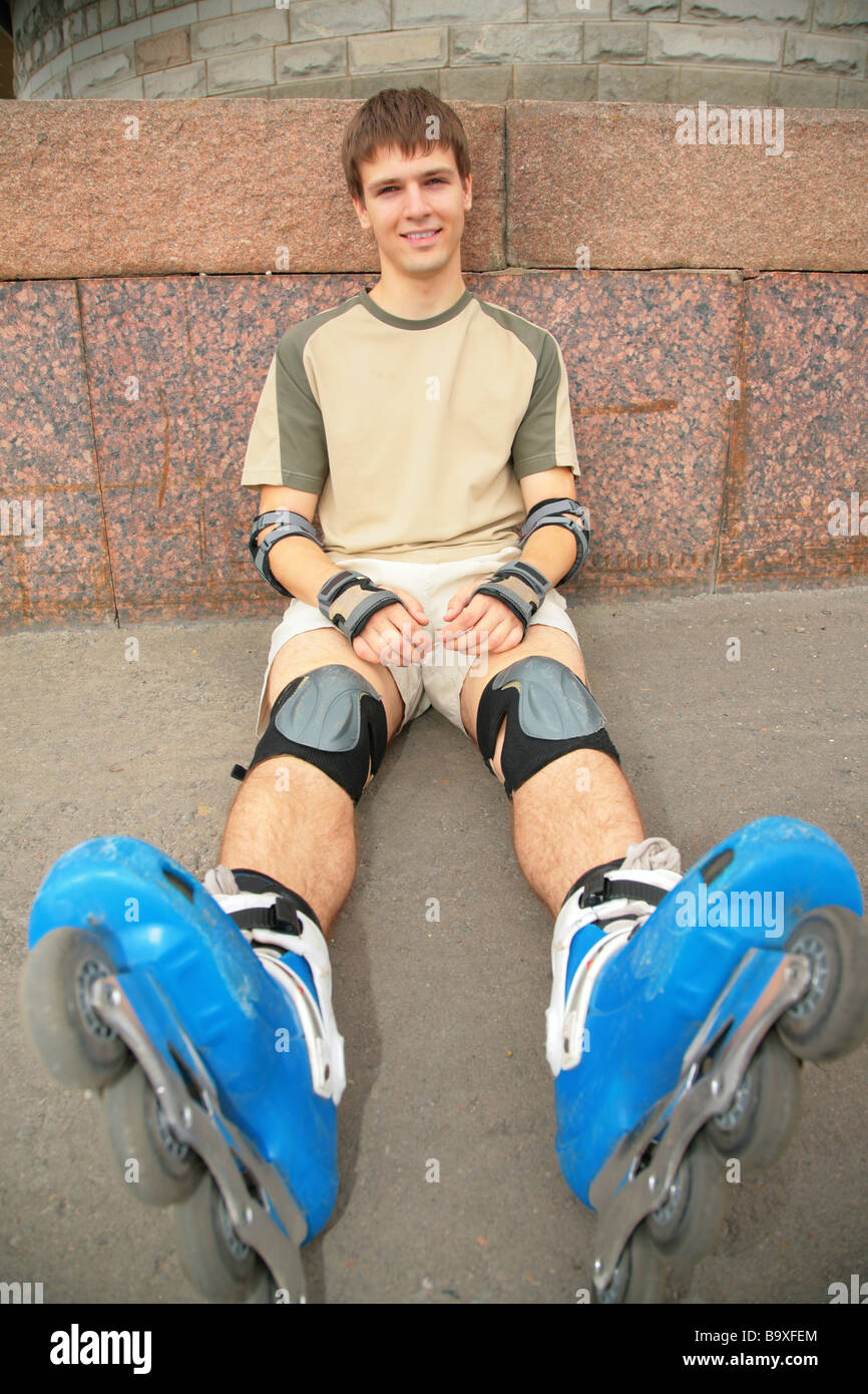 Sitting guy in rollerblades Stock Photo - Alamy