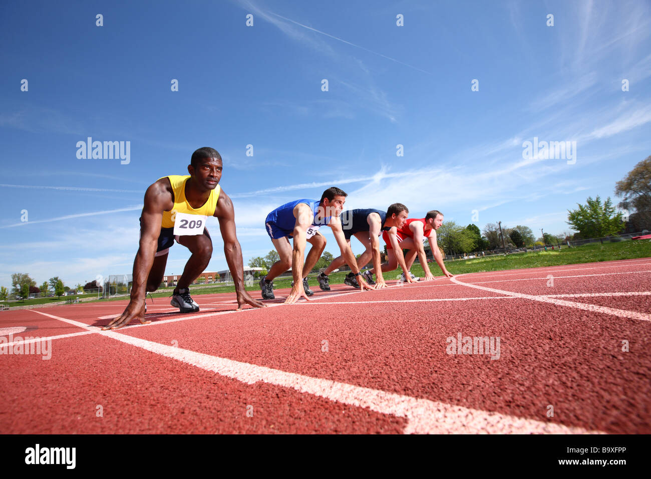 Track runners at starting line Stock Photo - Alamy