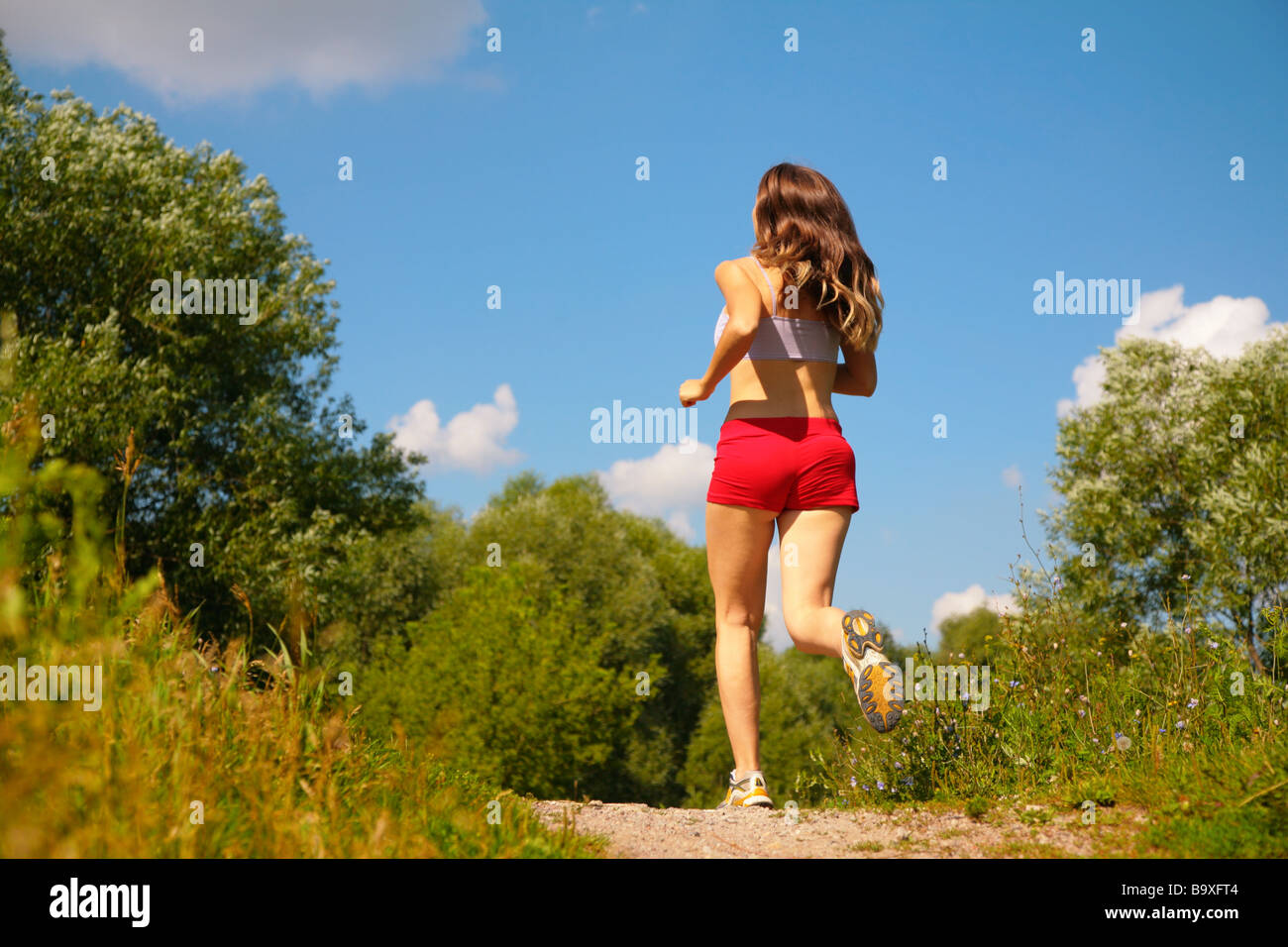Behind Girl running in forest Stock Photo - Alamy