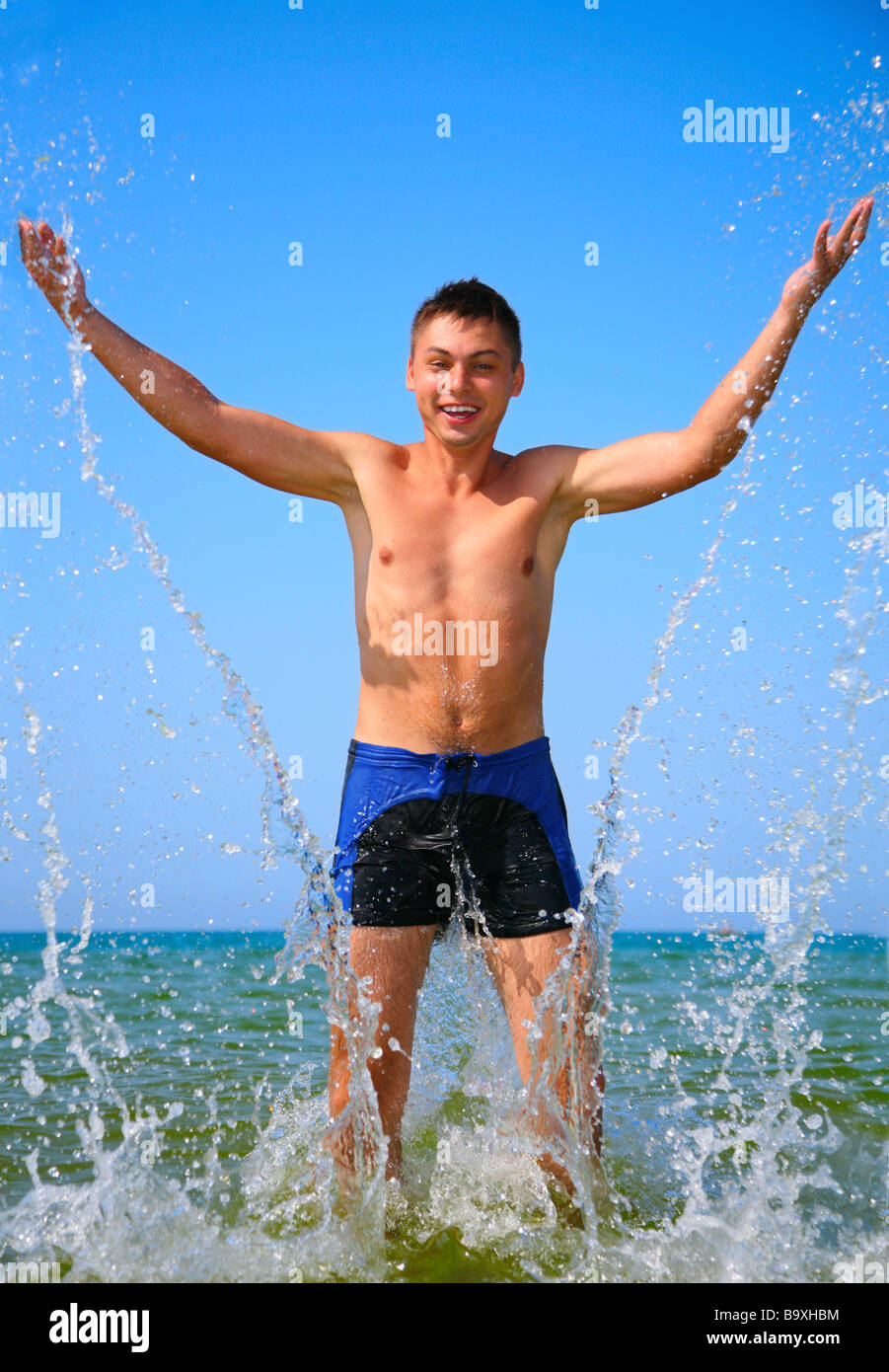 Man in sea water splash Stock Photo - Alamy