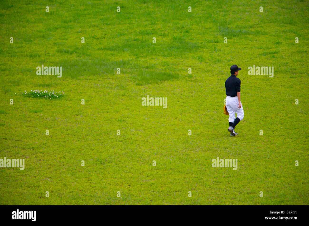 Baseball player walking on grass Stock Photo - Alamy
