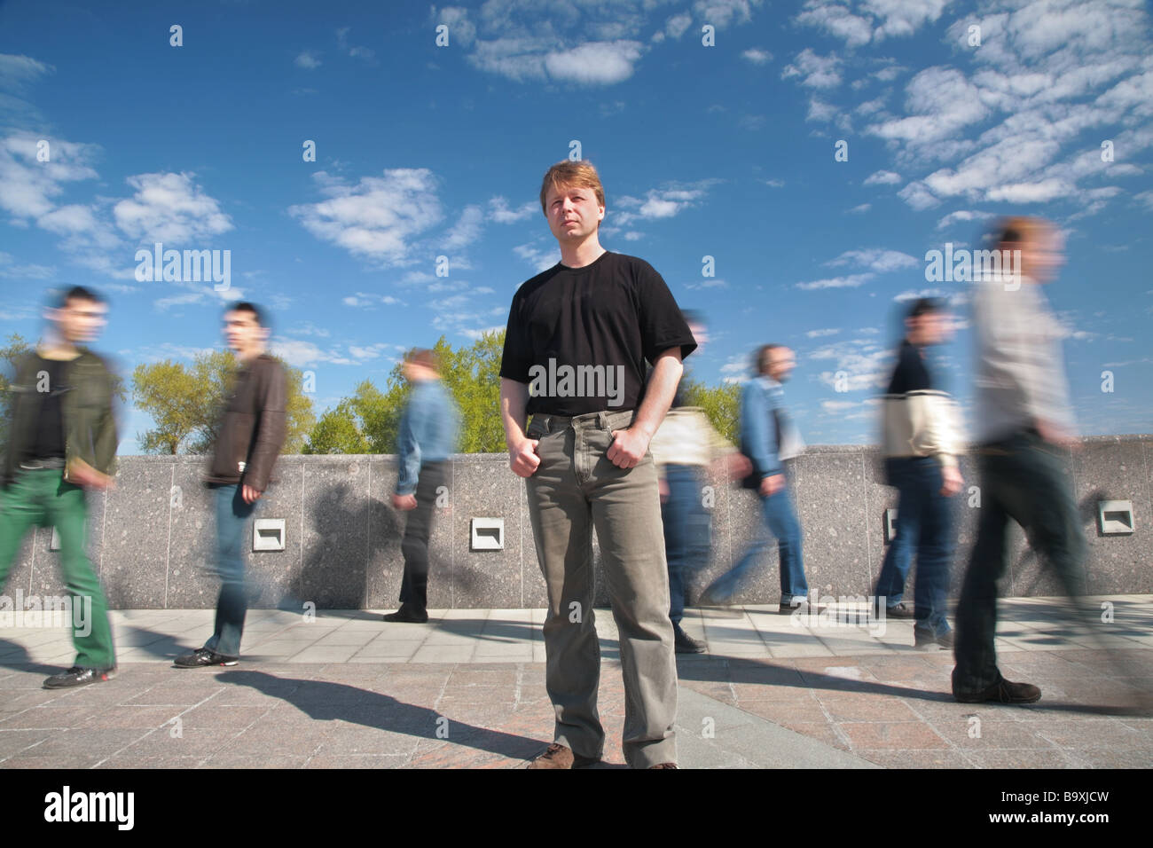 standing man among moving pedestrians Stock Photo - Alamy