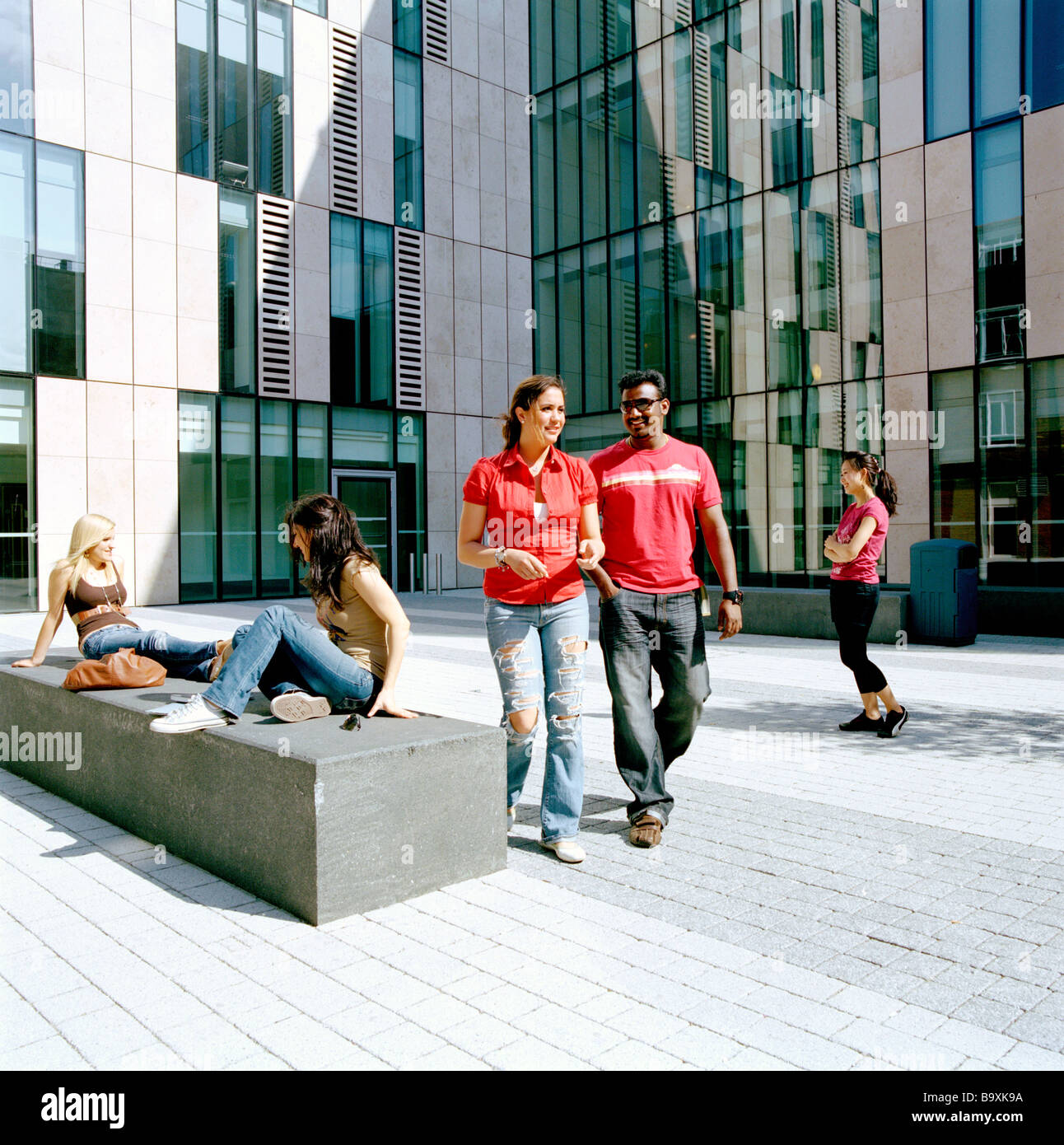 University campus, building, young students hanging out, taking it easy ...