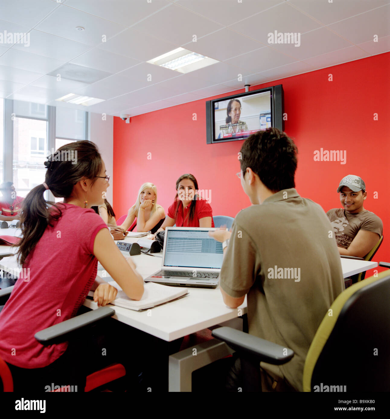 students laughing, discussing topics together in study room, working on ...