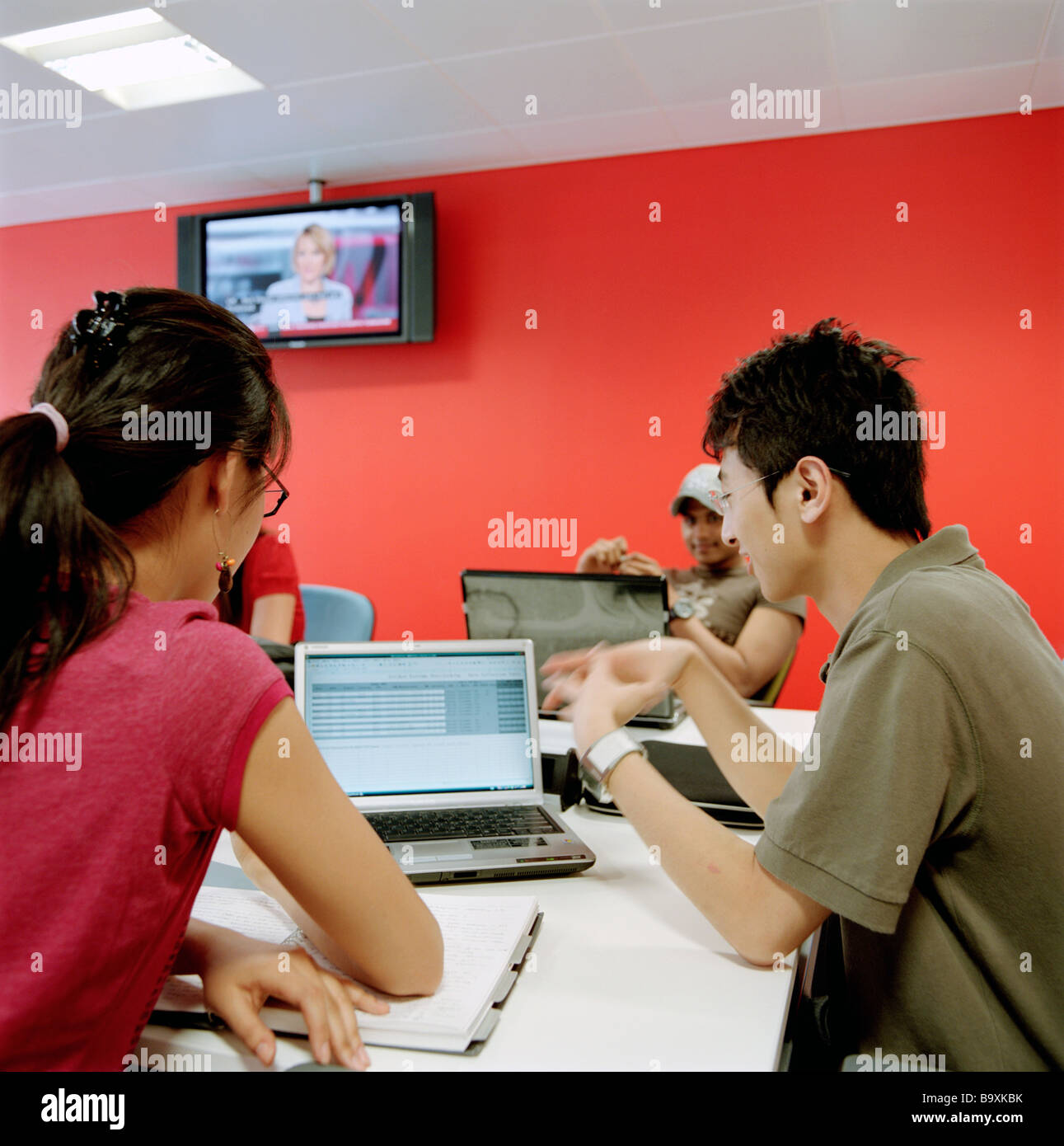 students laughing, discussing topics together in study room, working on ...