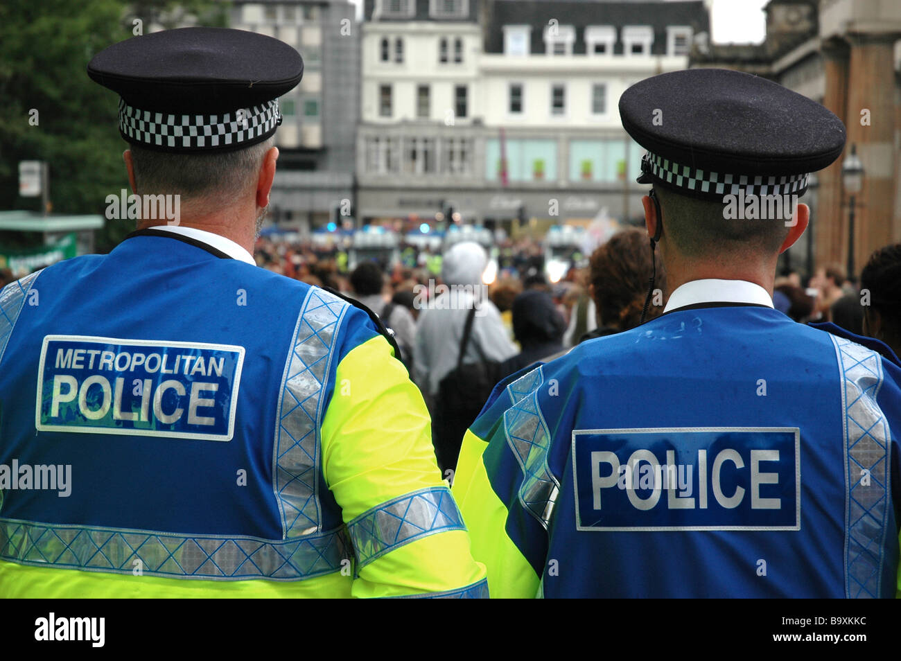 Metropolitan police officers watching a crowd of people at a ...