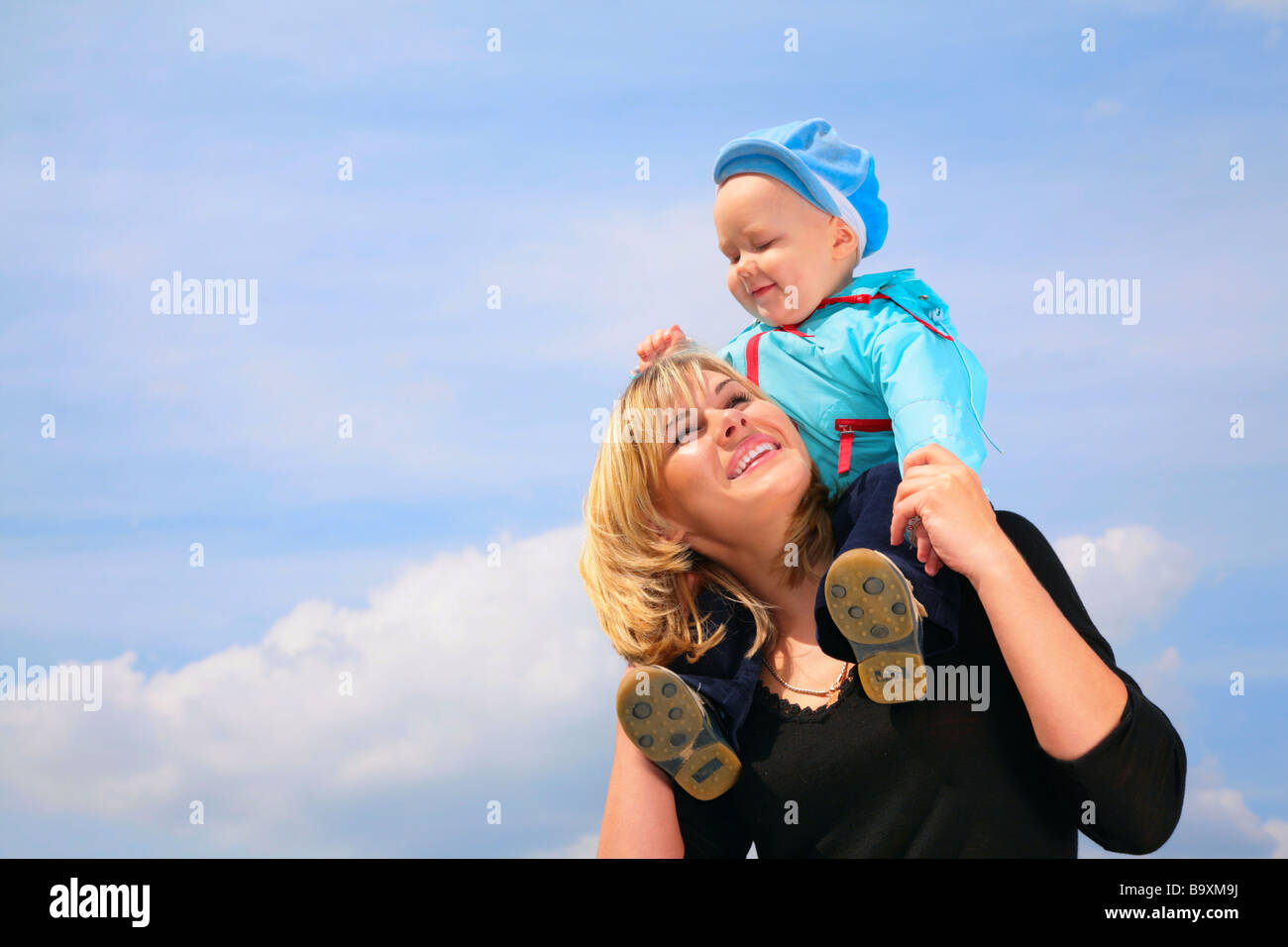 Mother with child on shoulders Stock Photo - Alamy