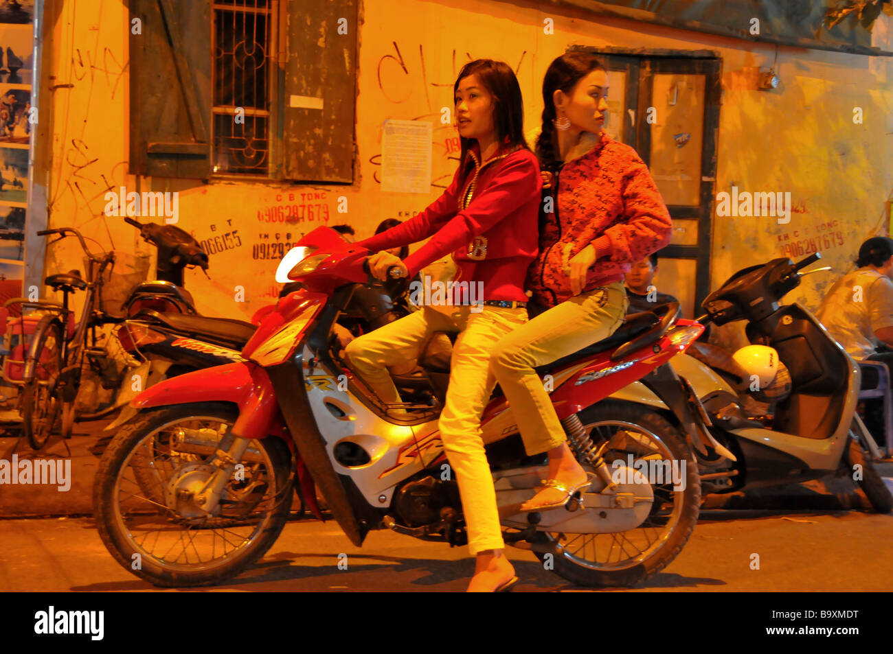 Vietnamese women on a motorbike at night in Hanoi Stock Photo - Alamy