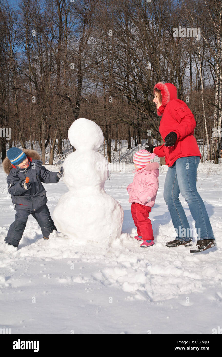 mother and children make snowman Stock Photo - Alamy