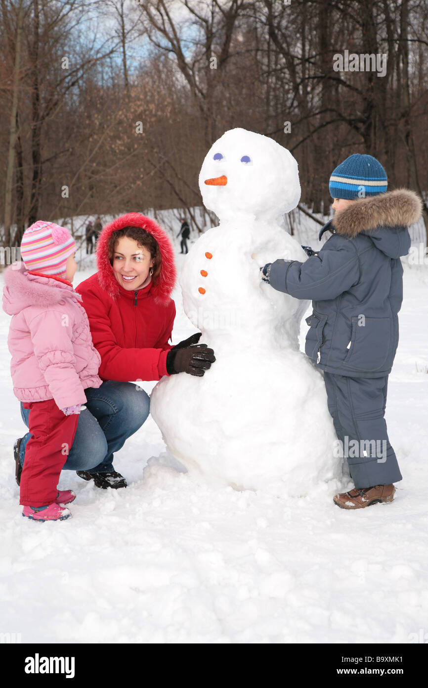 mother and children make snowman Stock Photo - Alamy