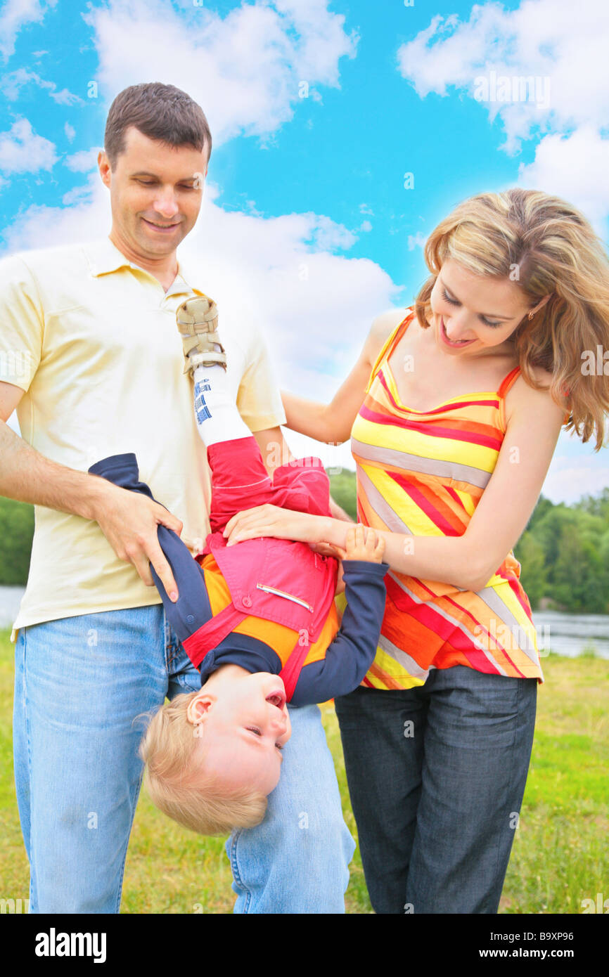 Parents hold child beneath by head Stock Photo - Alamy
