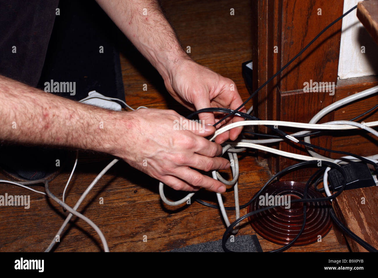 Hands untangling electronics wires Stock Photo - Alamy