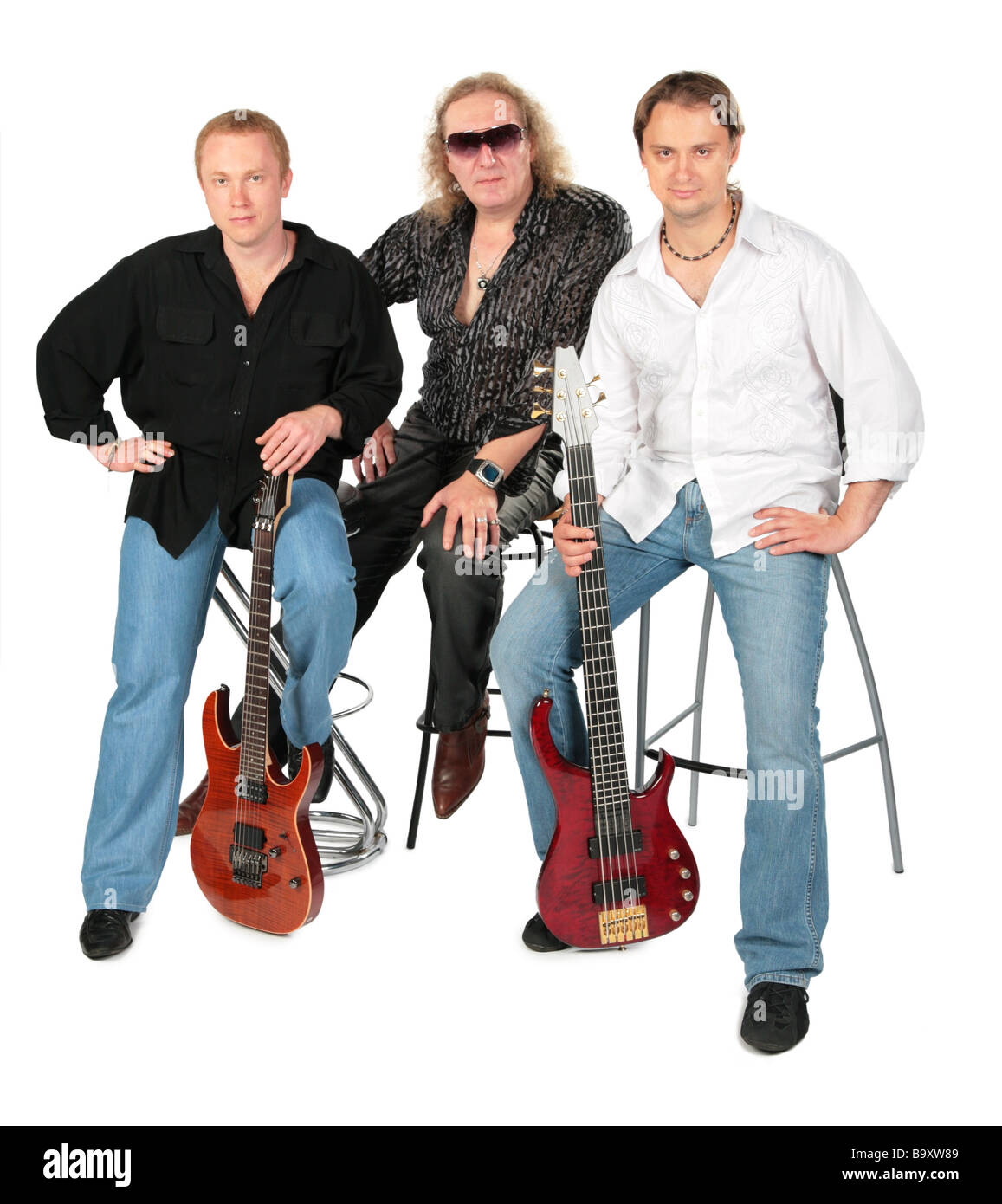 Three sitting men with two guitars. Music group Stock Photo - Alamy