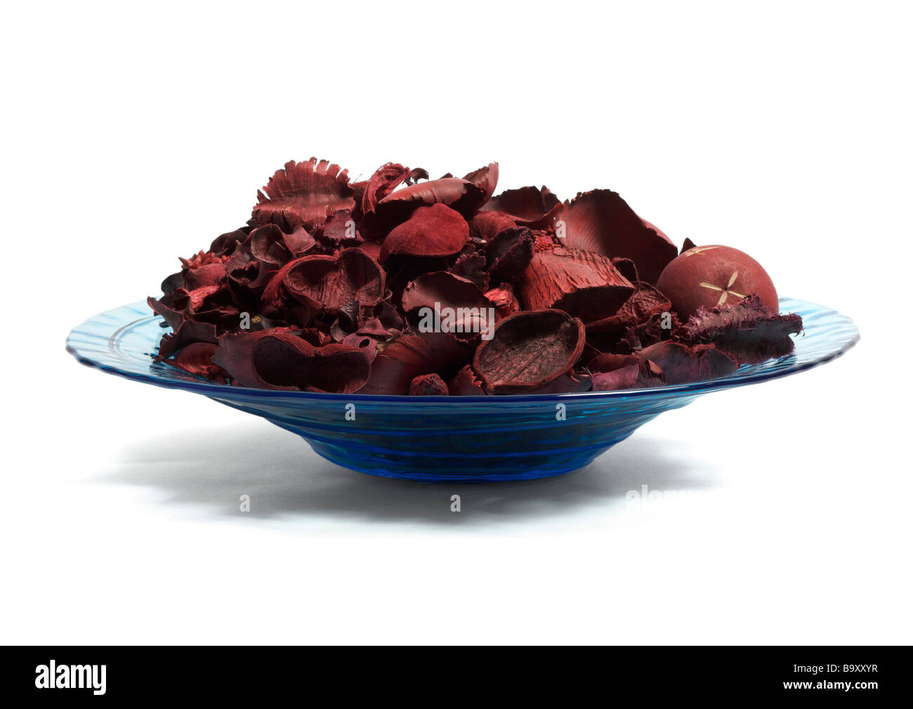 Blue glass bowl filled with red potpourri on white background Stock ...