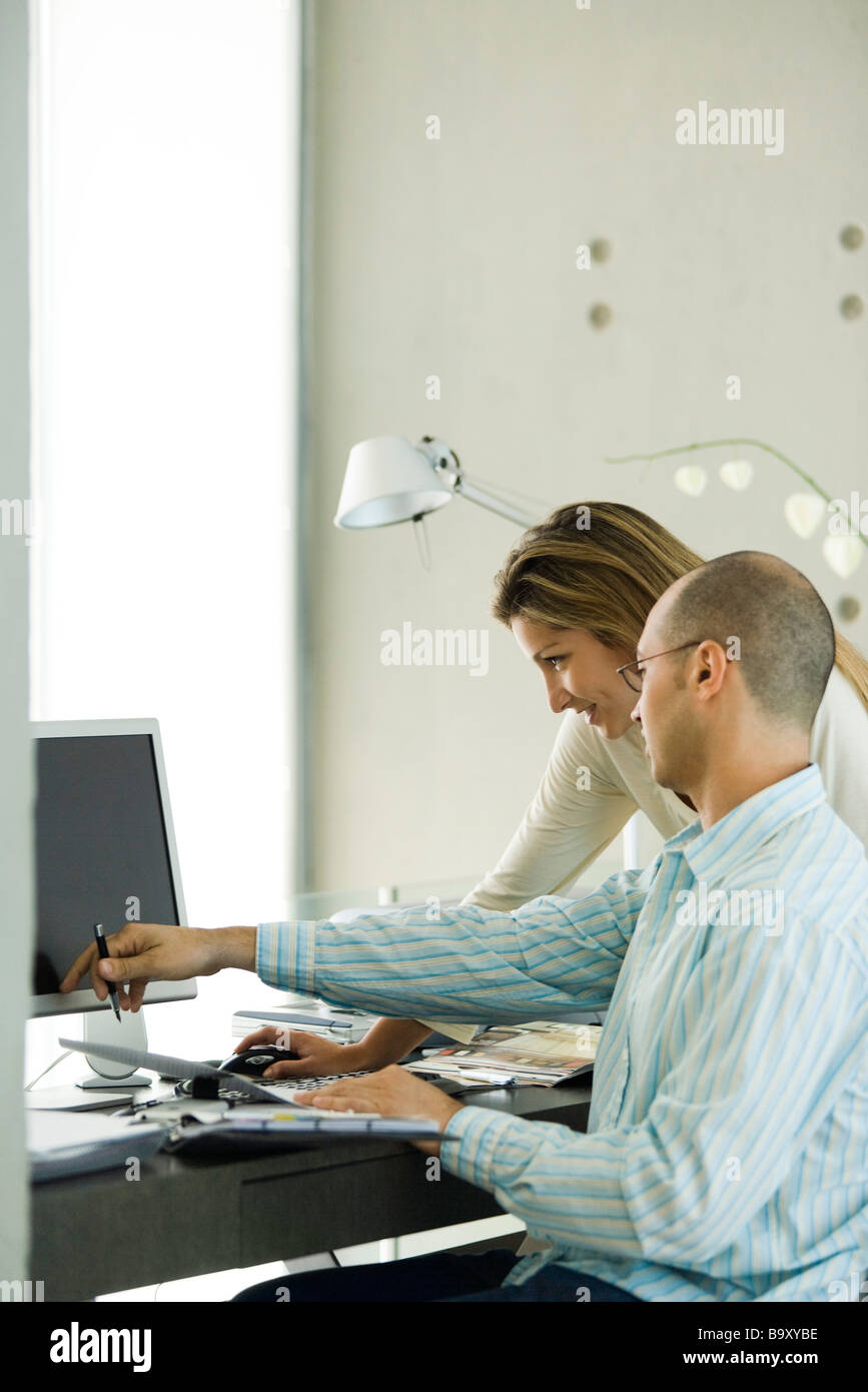 Couple in home office, looking at computer together Stock Photo - Alamy
