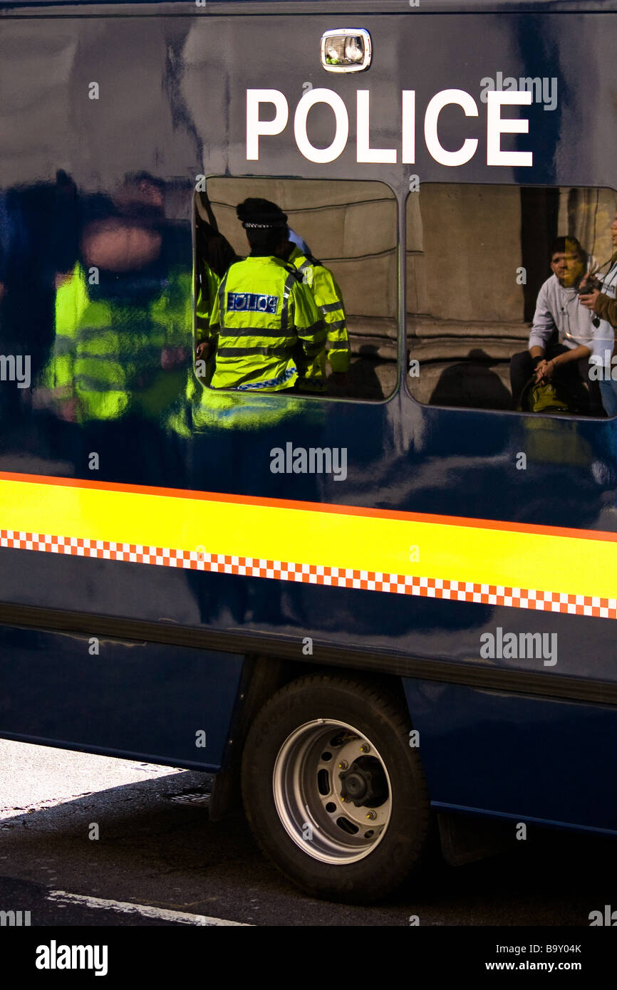 The side of an armoured police van showing the reflections of police ...