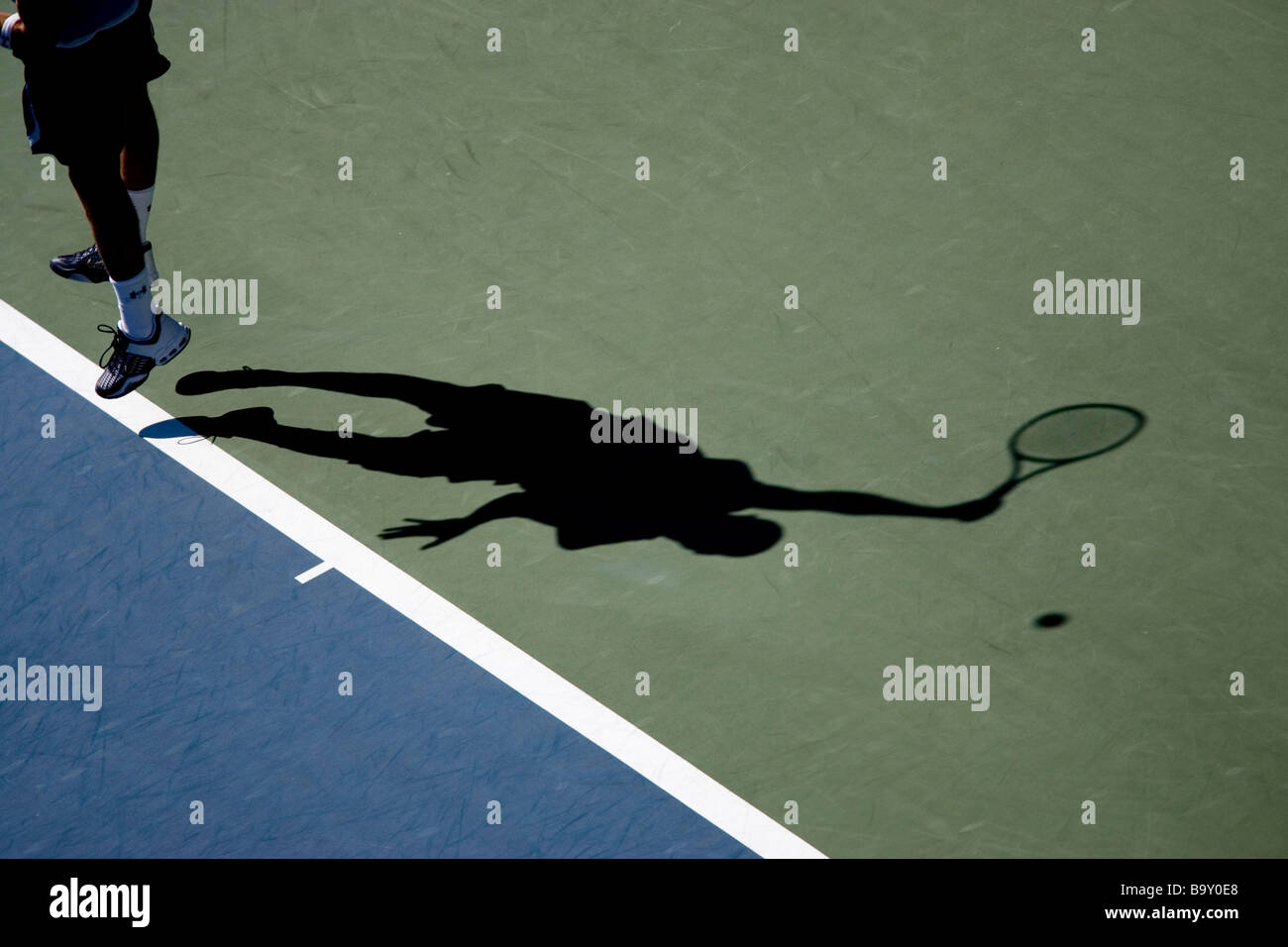 Shadow of tennis player serving Stock Photo - Alamy
