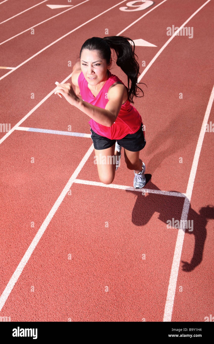 Female athlete running on track Stock Photo - Alamy