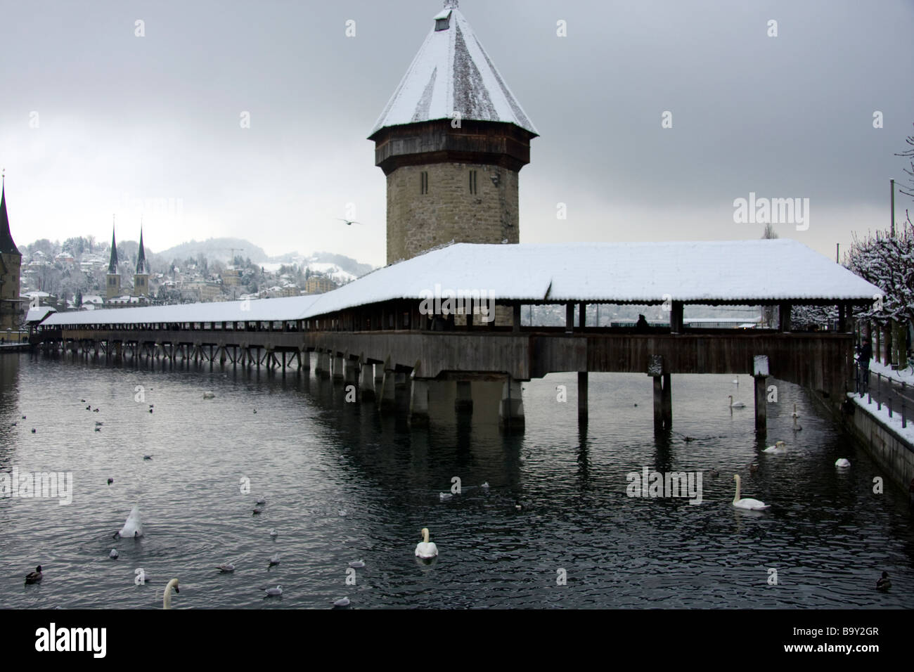 The Kapellbrücke Chapel Bridge covered in snow crosses the Reuss River ...