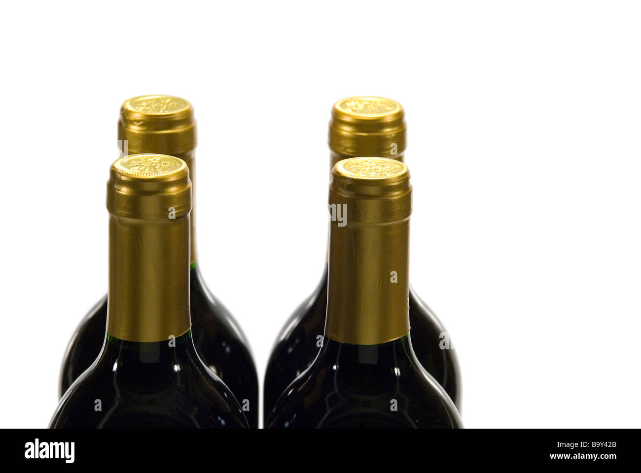 Four botteles of red wine Isolated on white Golden bottle caps Stock ...