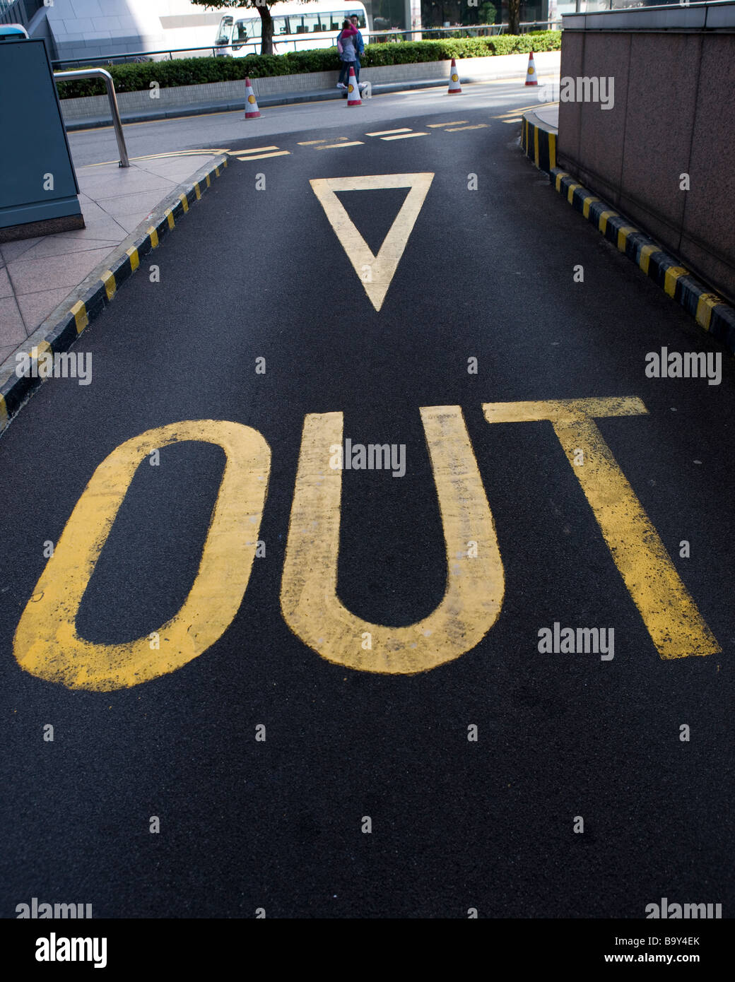 Yellow sign on the asphalt road. Marking on the street which says out ...