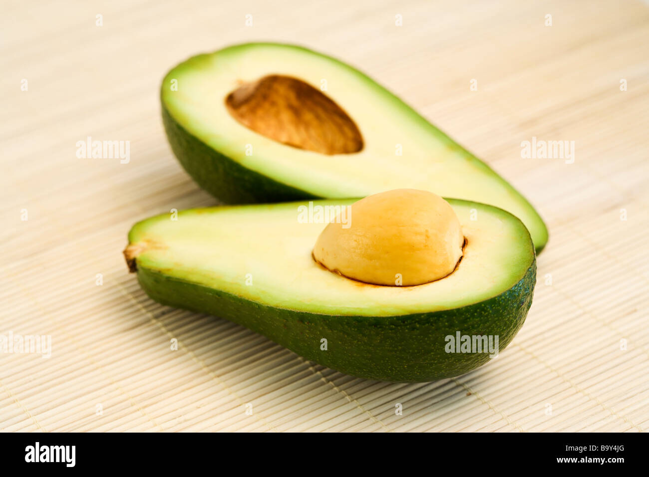 avocado halves on strawmat Stock Photo - Alamy