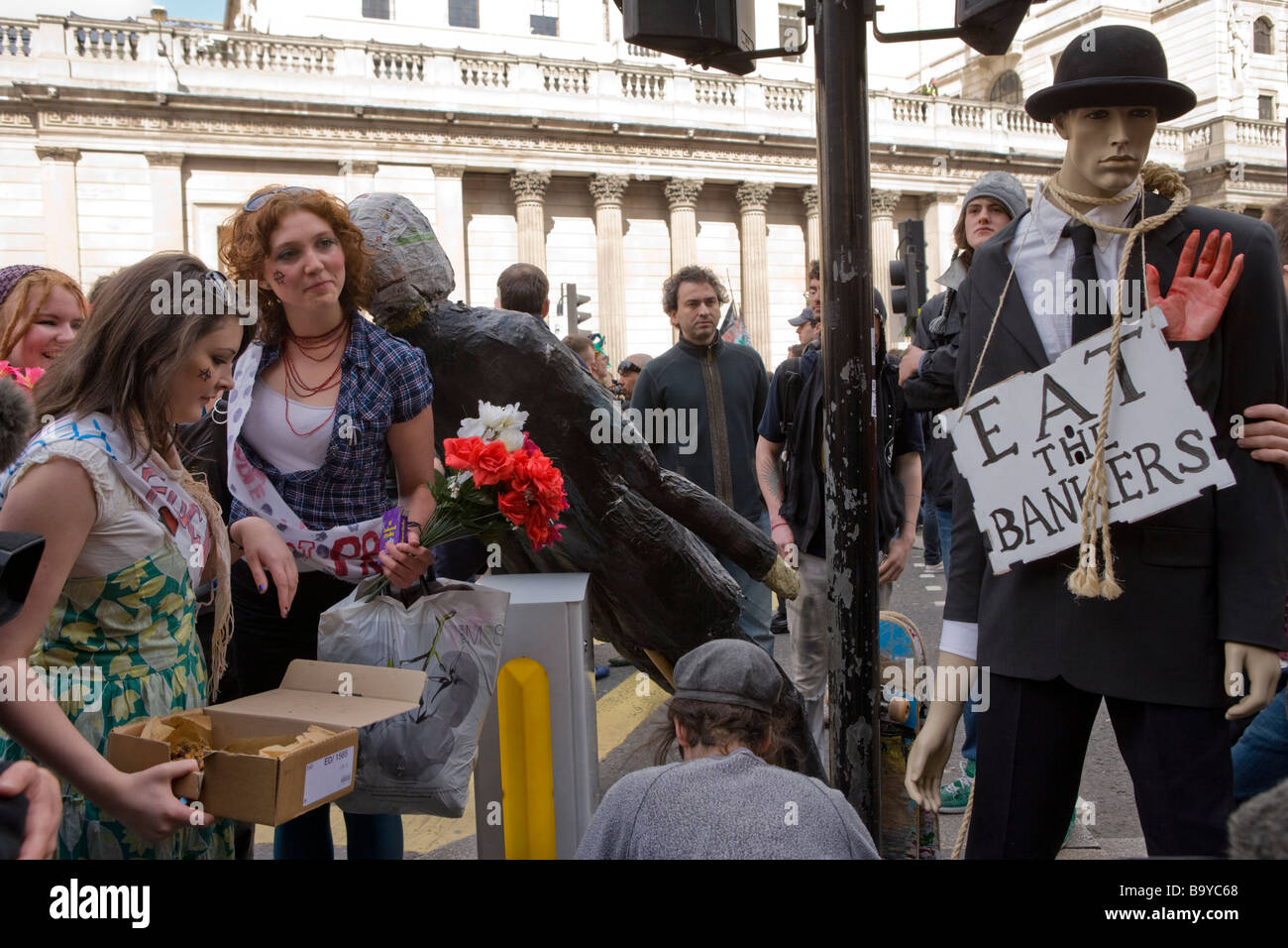 Manequin of banker with rope around its neck with placard "Eat The ...