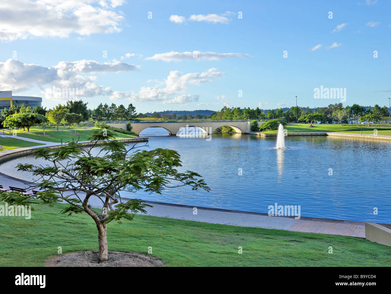 Man made lake with water feature and road bridge Stock Photo - Alamy