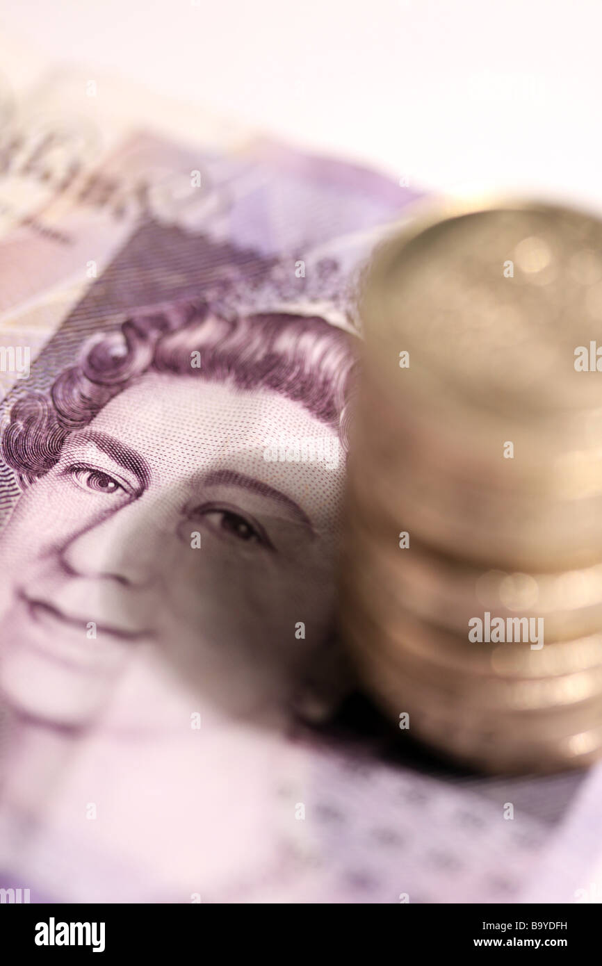 Twenty pound note with a stack of one pound coins on top Stock Photo ...
