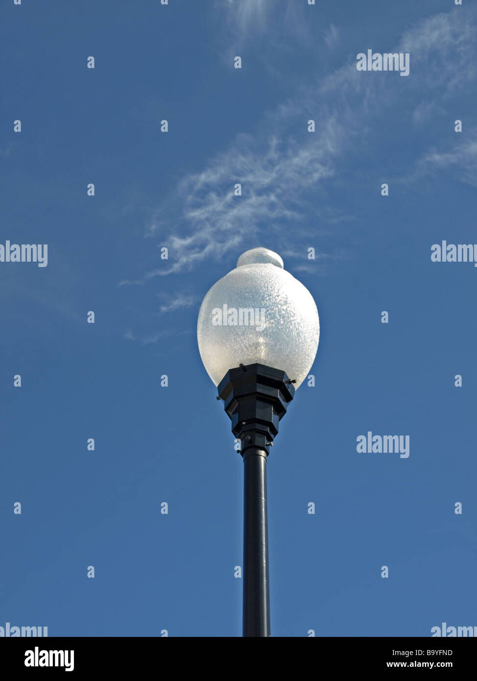 white globed globe street lamp viewed from below looking into blue sky ...