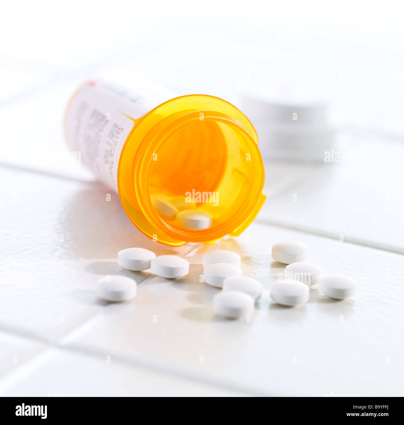 Pill bottle with pills spilled out on a tile surface Stock Photo - Alamy