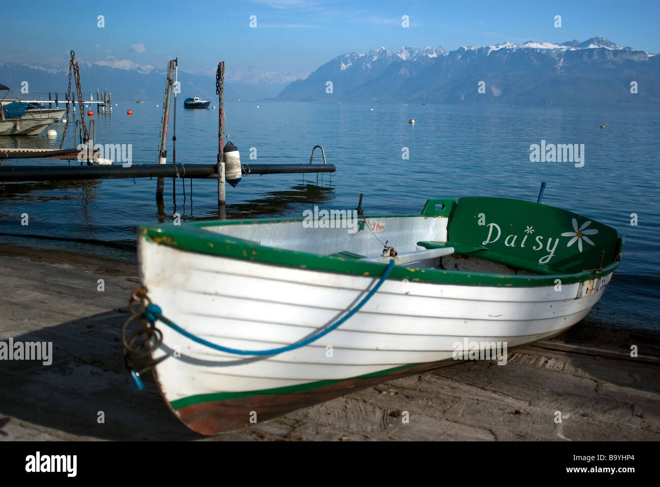 A boat on lake Léman framed by the alps at the marina in Ouchy ...